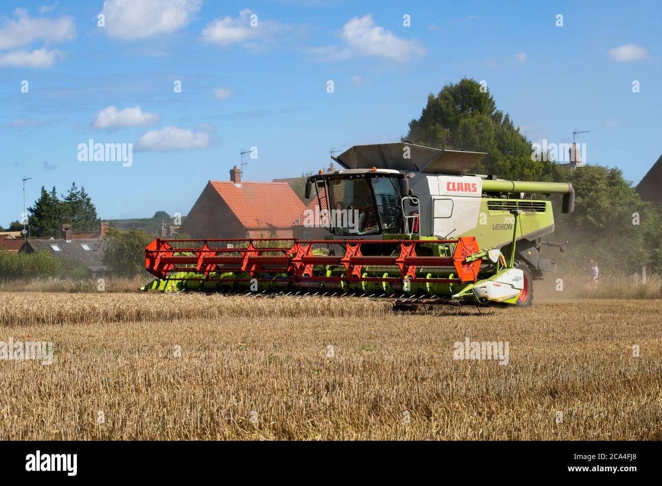 Winter Harvest Close side view of combined harvester at work in field ...