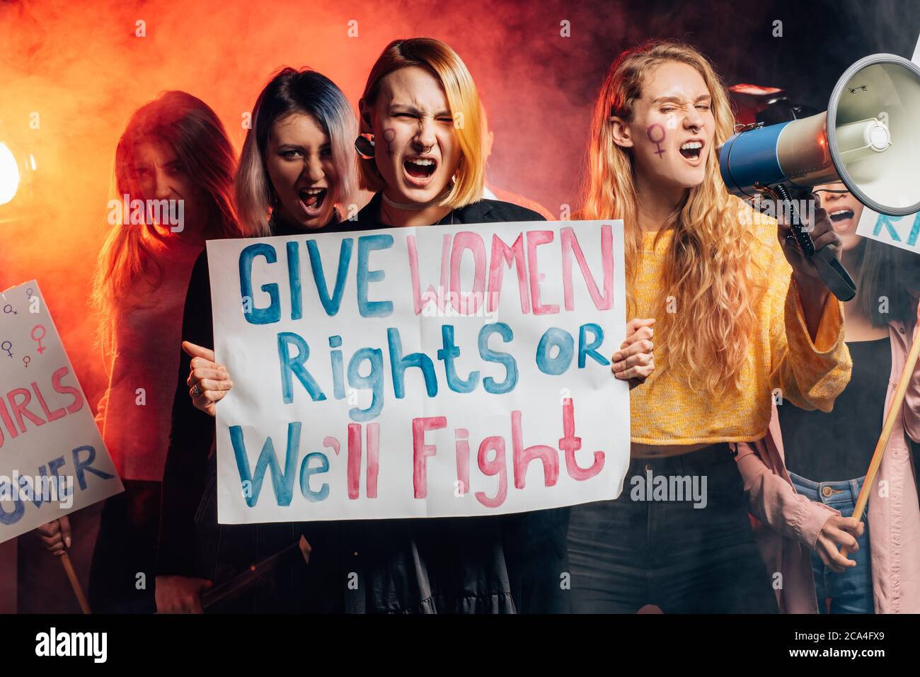 group of feminists girls standing with bats, megaphones and posters ...