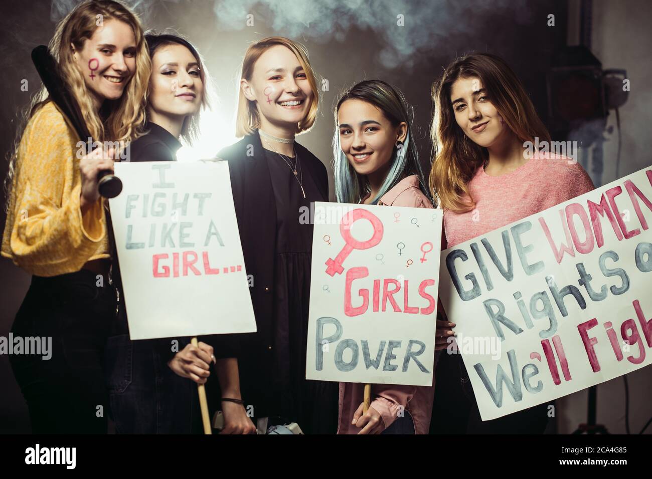 young beautiful women stand together in smoky space fighting for girls ...