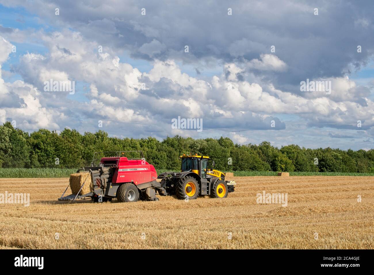 Baling after the harvest Tractor towing bailer ejecting bale onto the ...