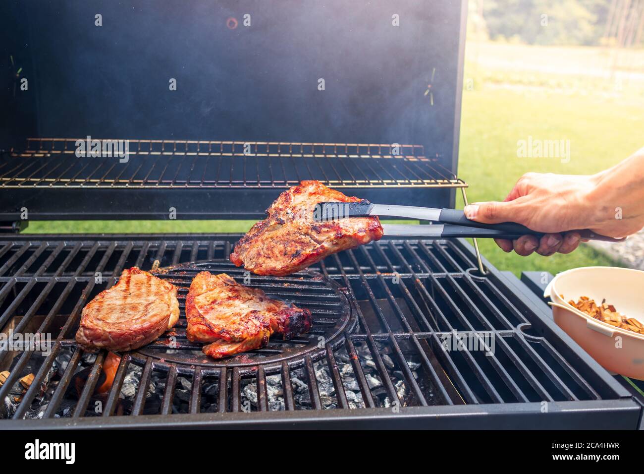 Home barbecue with charcoal in the backyard grilling steaks and other ...