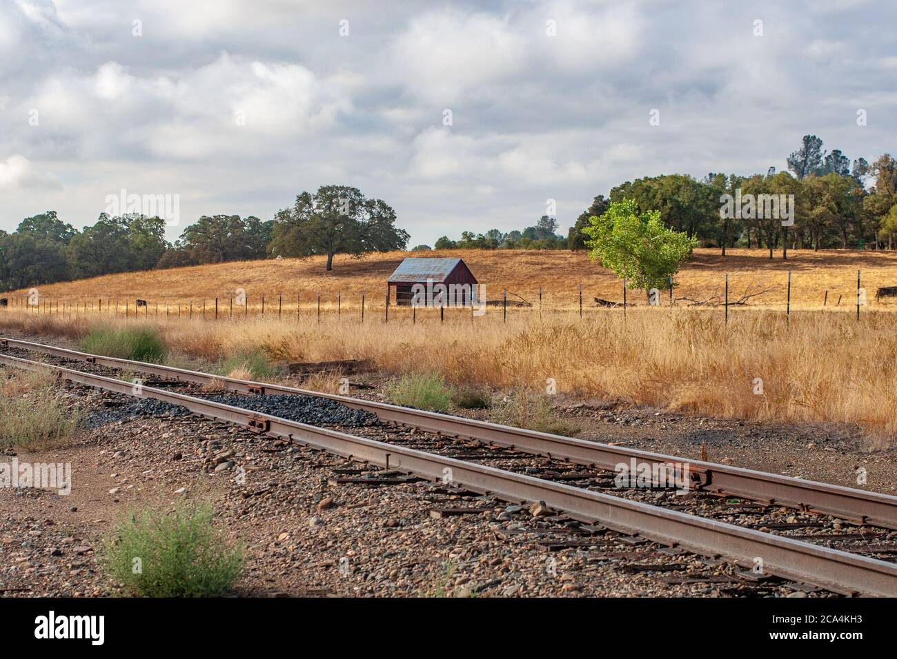 A train track running in front of Californian farmland Stock Photo - Alamy