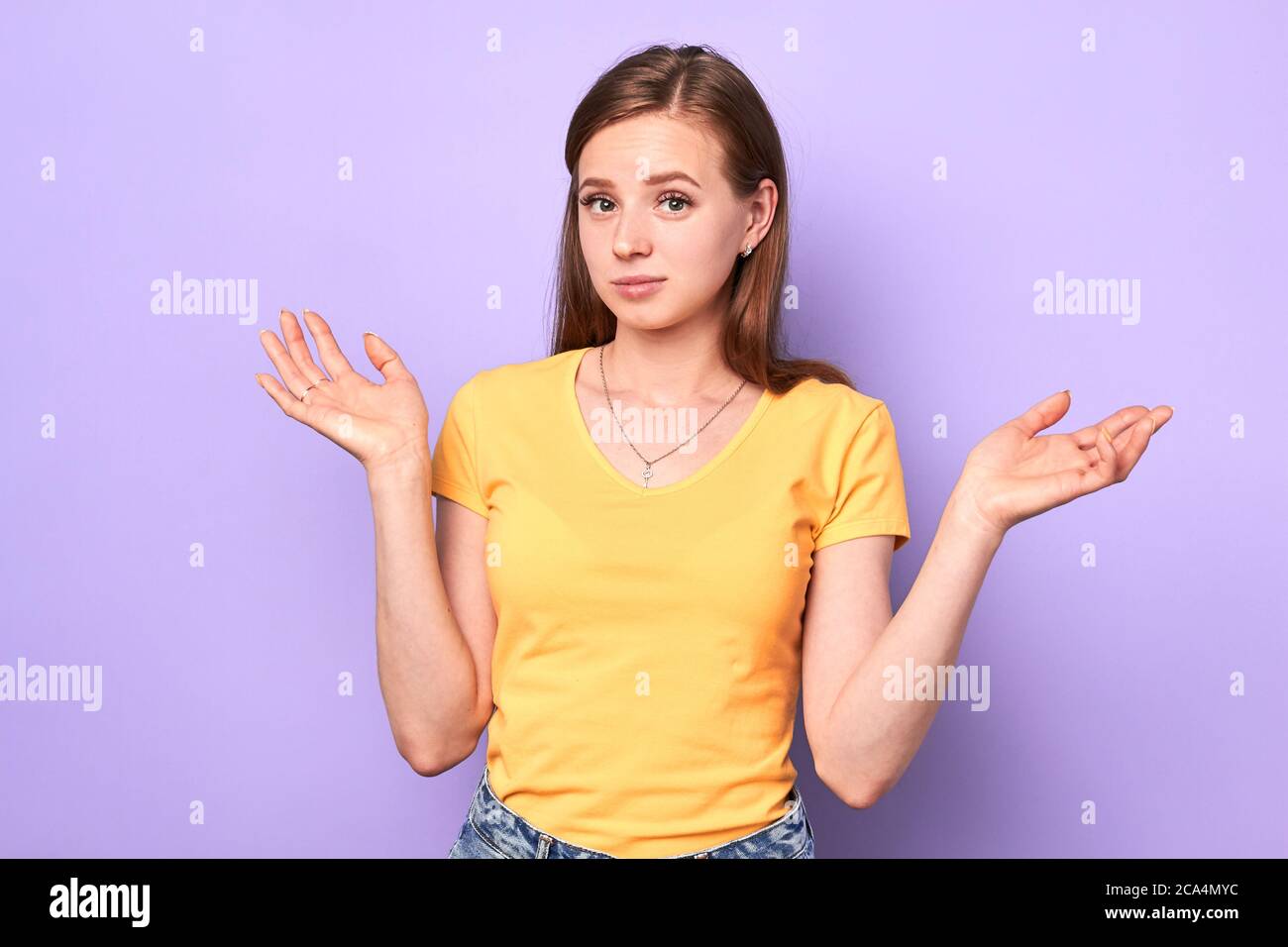 Front view of clueless female student spreads palms, has unaware and ...