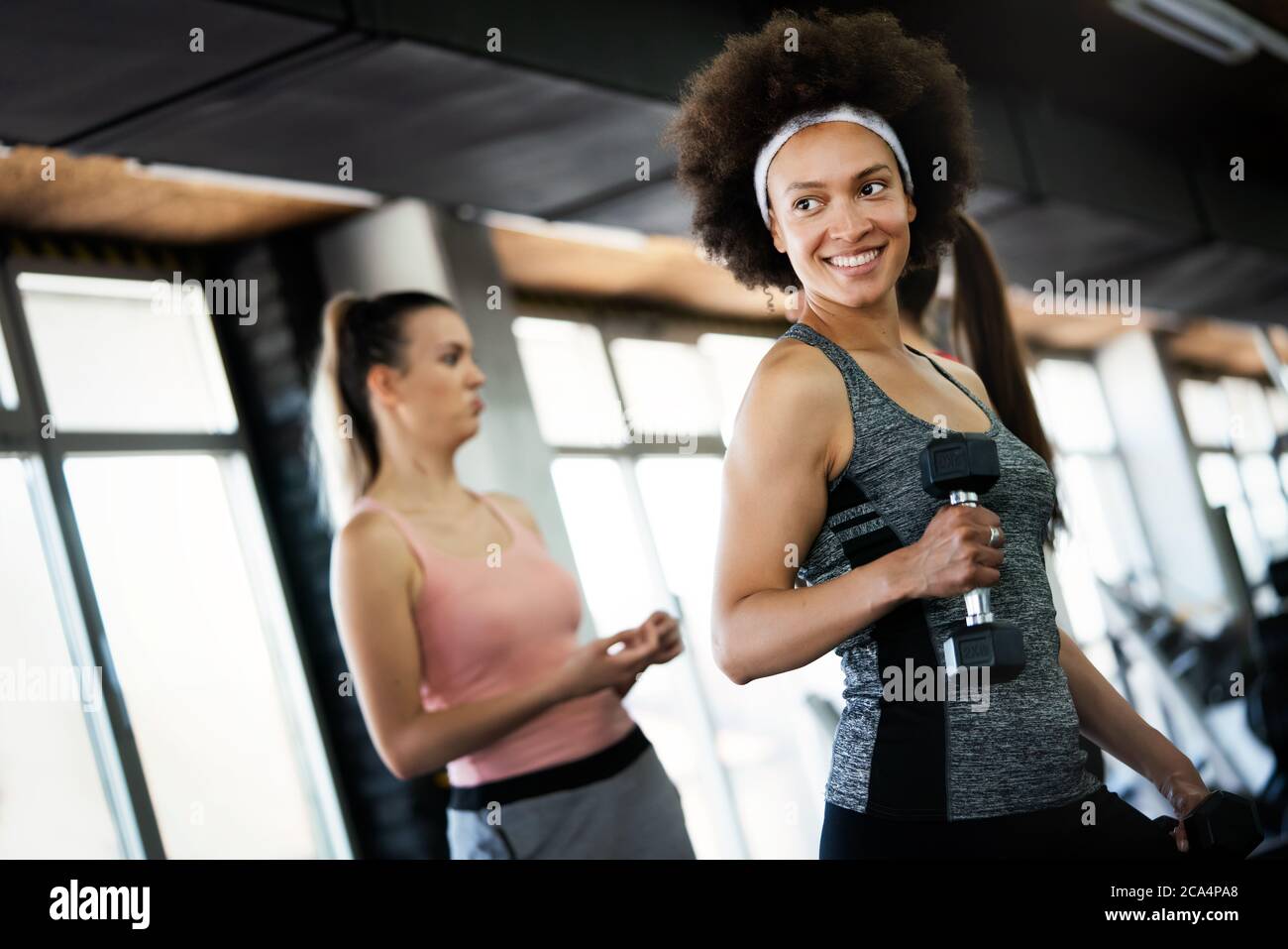 Beautiful fit people exercising together in gym Stock Photo - Alamy