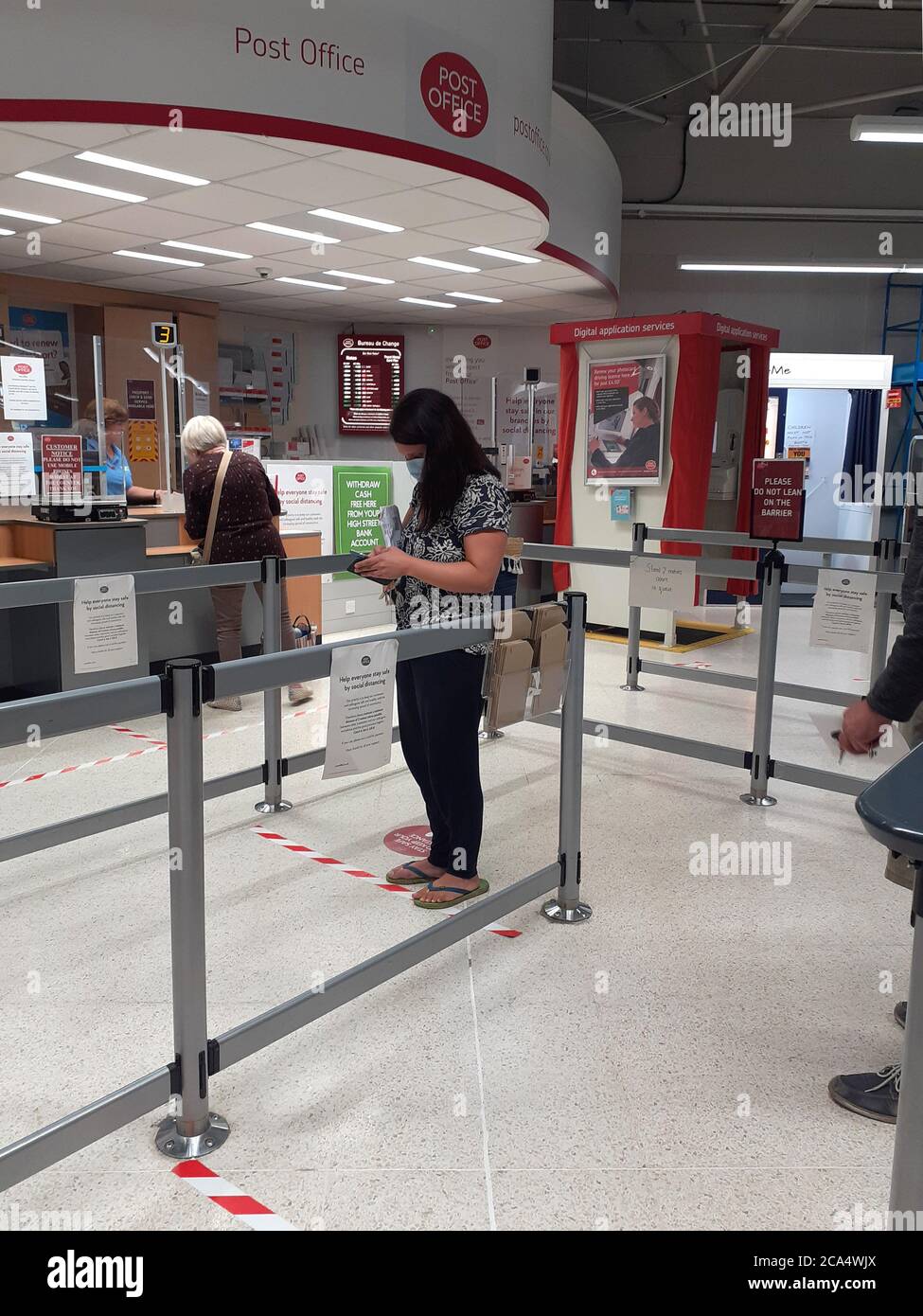 queue of people in post office at height of restrictions waiting for ...