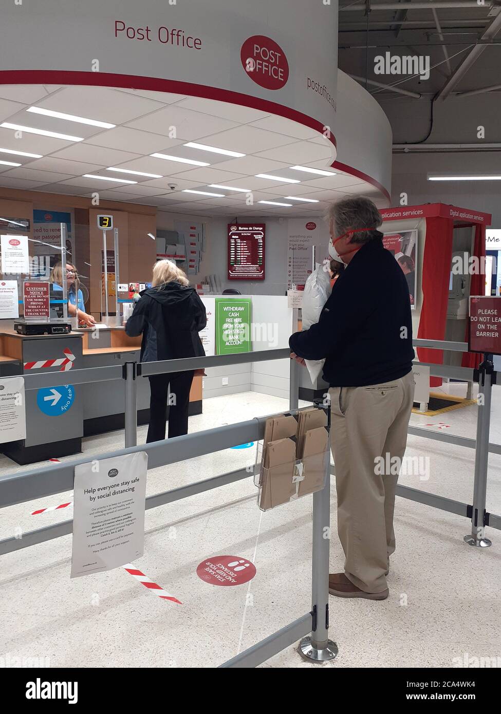 queue of people in post office at height of restrictions waiting for ...