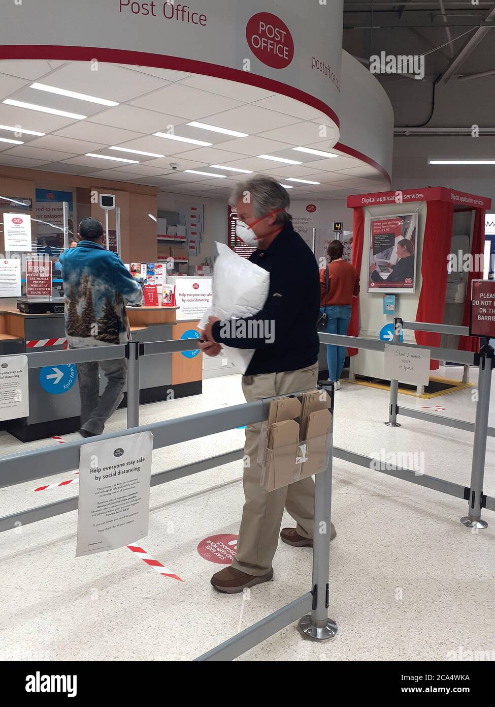 queue of people in post office at height of restrictions waiting for ...