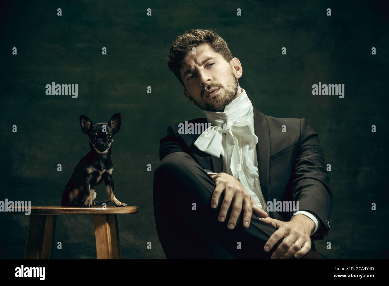 Youth forever. Young man in suit as Dorian Gray isolated on dark green ...