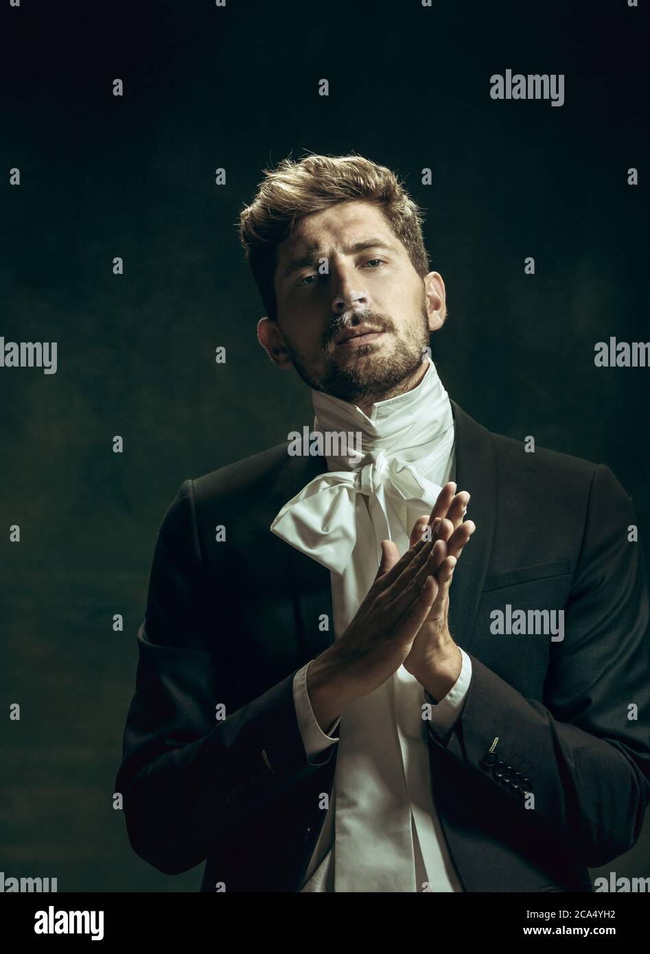 Opium. Young man in suit as Dorian Gray isolated on dark green ...