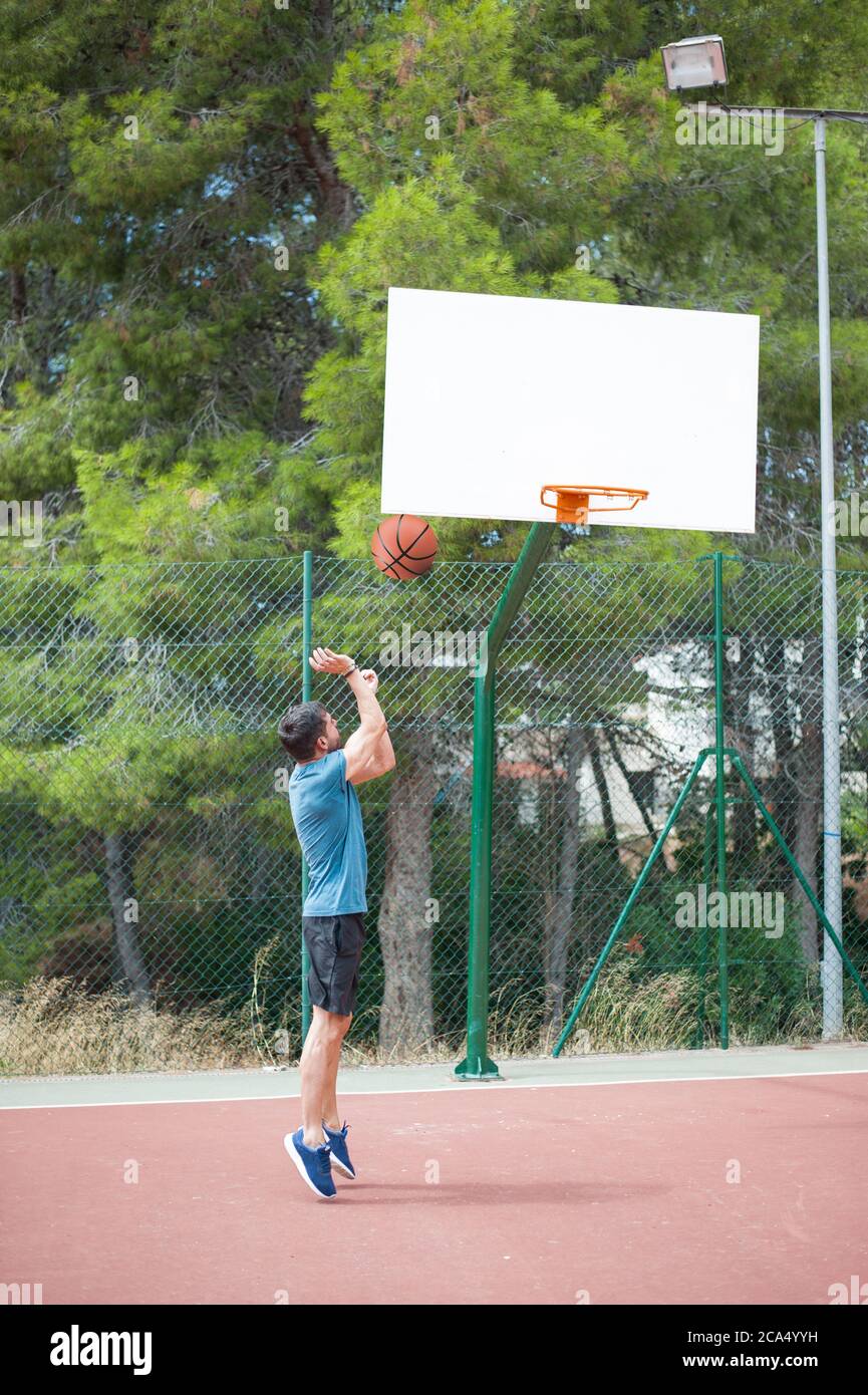 Muscle man playing basketball alone Stock Photo - Alamy