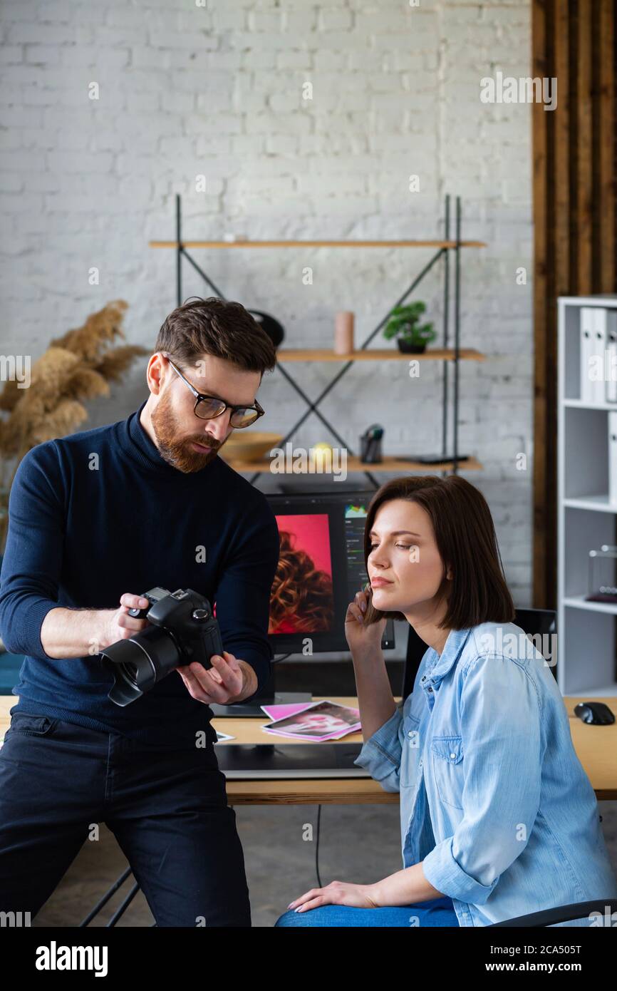 Photographer and graphic designer working in office with laptop ...