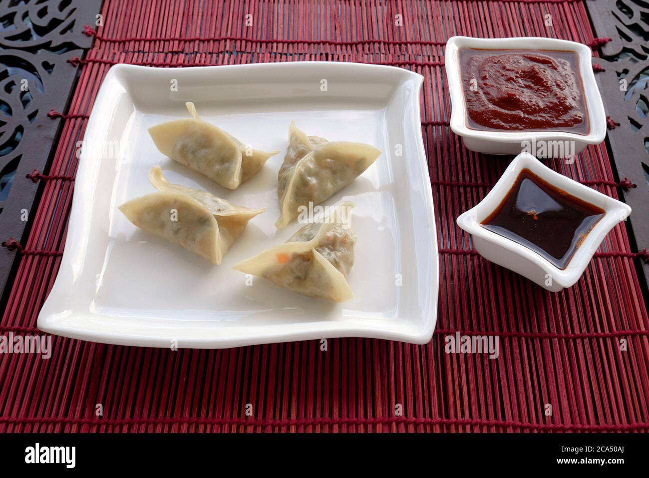 VEGETARIAN DIM SUM UNCOOKED WITH CHILLI OIL AND SCHEZWAN SAUCE Stock ...