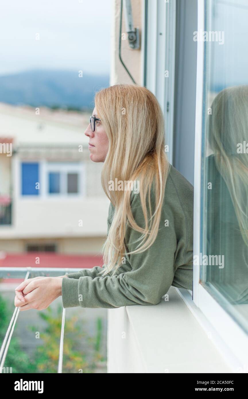 Woman looking outside window Stock Photo - Alamy