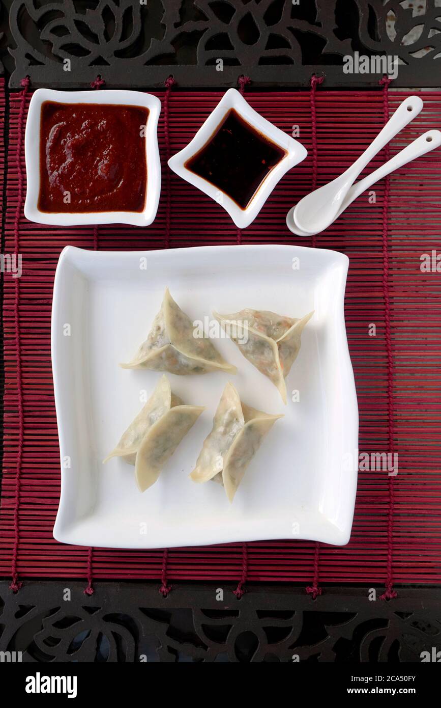 VEGETARIAN DIM SUM UNCOOKED WITH CHILLI OIL AND SCHEZWAN SAUCE Stock ...