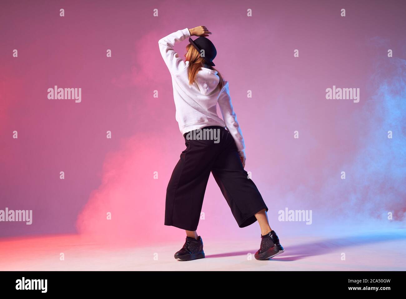 Back shot of woman dancing in white smoke on stage of dancing school ...