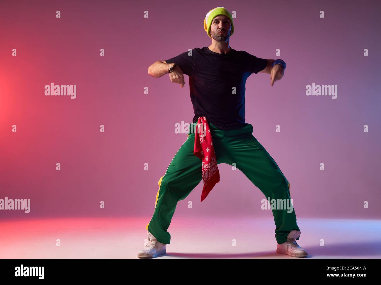 Brutal beard male dressed in sportive clothes, dancing hip hop on stage ...