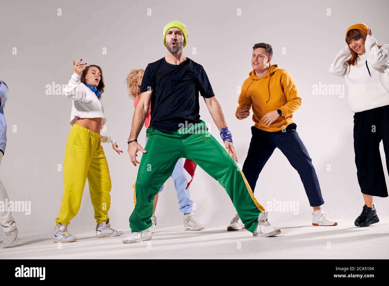 Handsome tall professional trainer teaching young teenagers how to ...