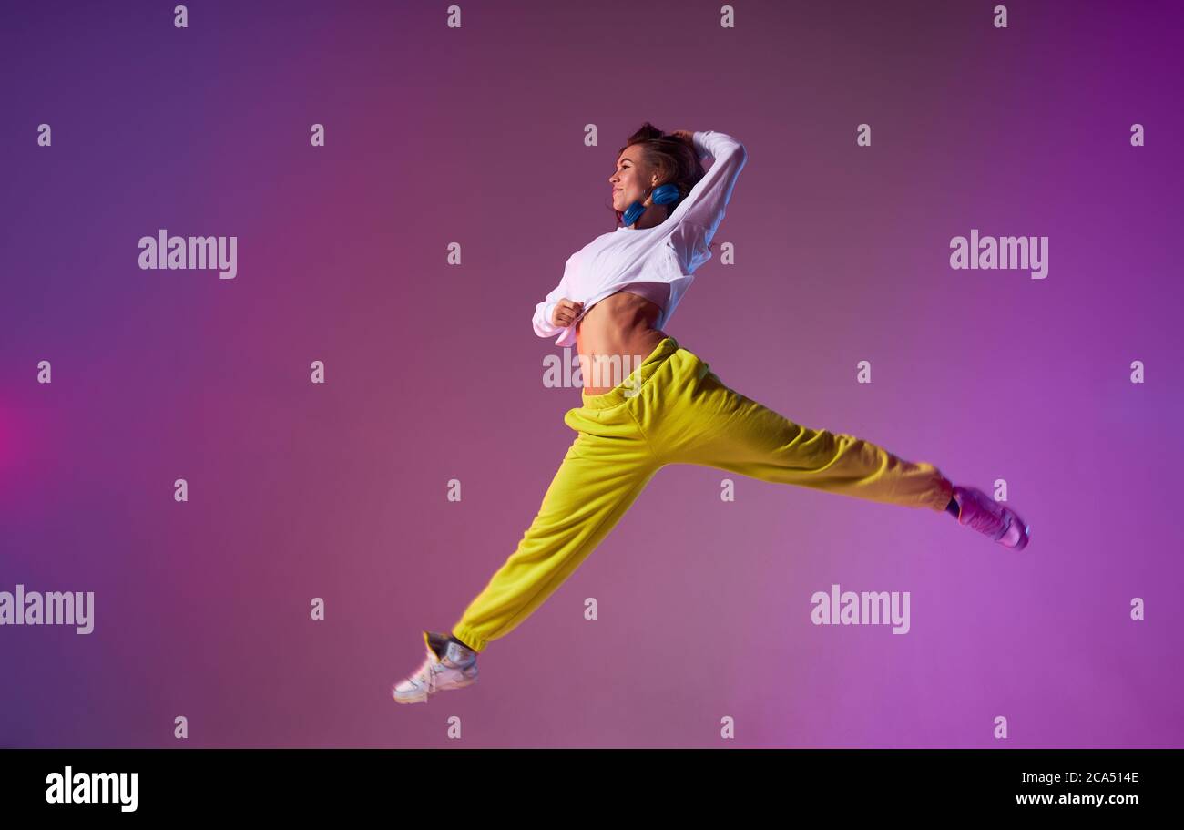 Charming young lady jumping high making acrobatics movies in the air ...