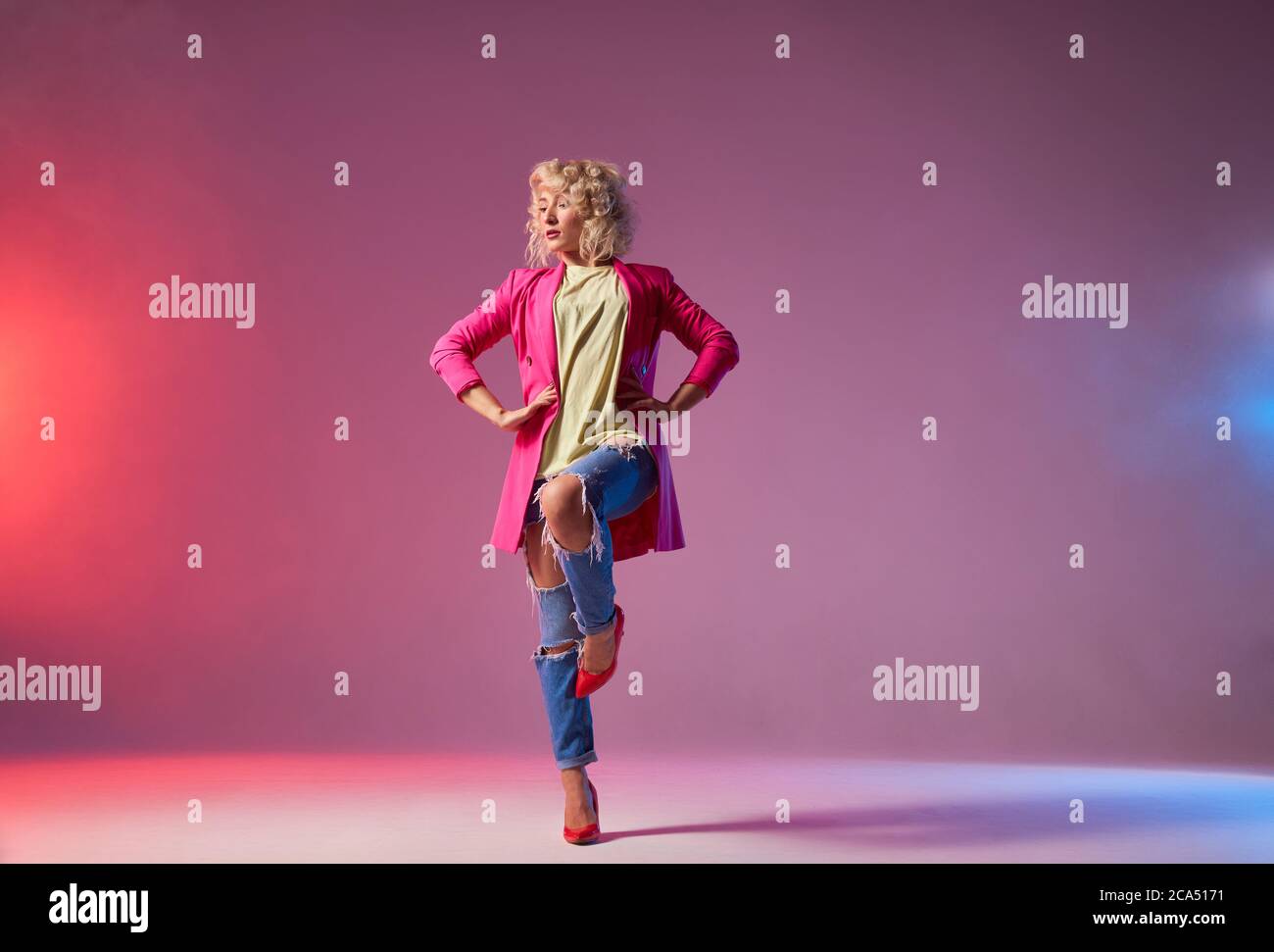 Pretty female dancer with long curly hair performing on dance ...