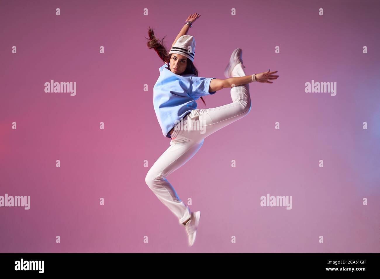 Flexible professional female dancer jumping in energetic dance ...