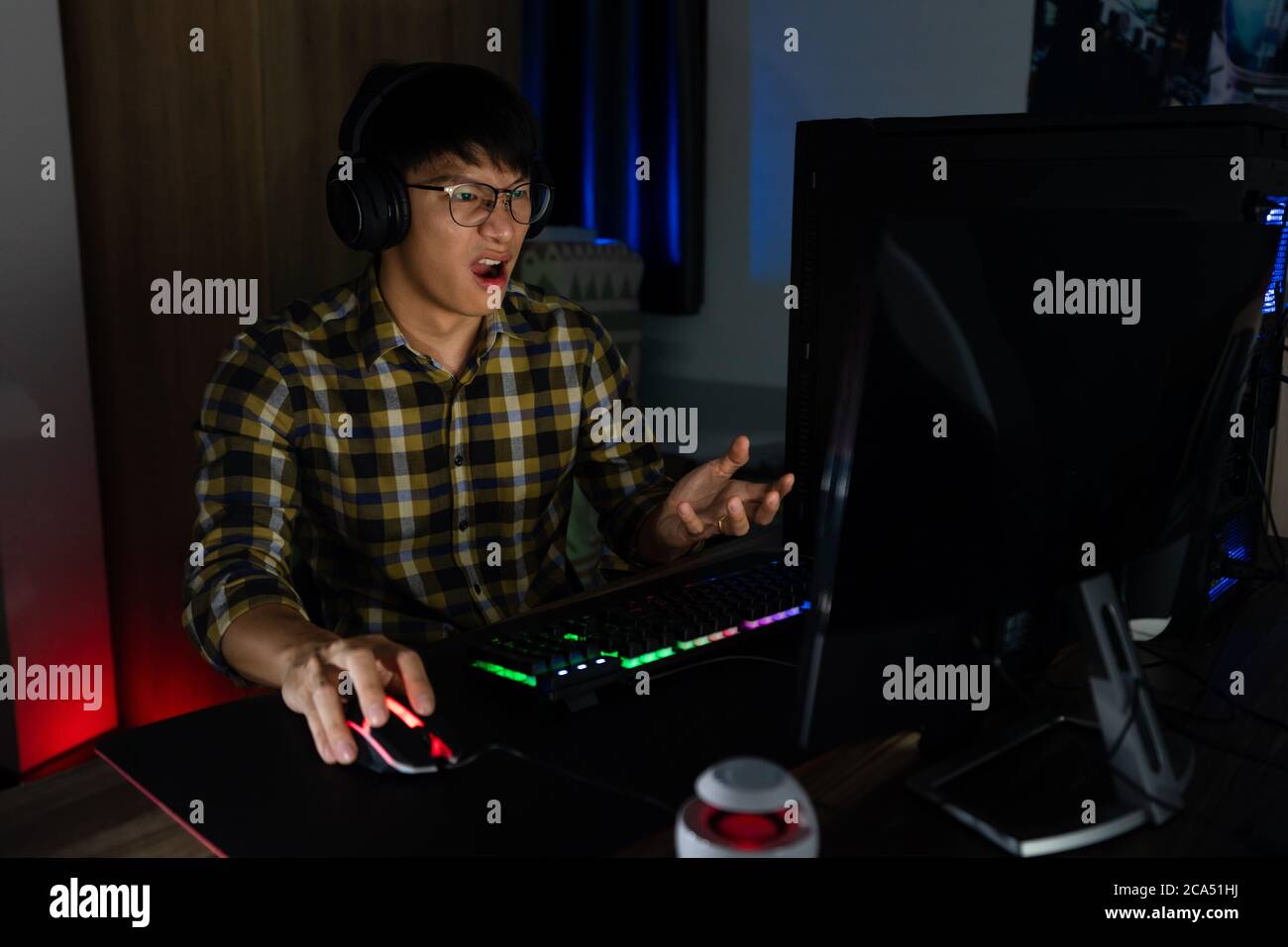 Asian man gamer in headphones stressed with hand feel depressed or ...