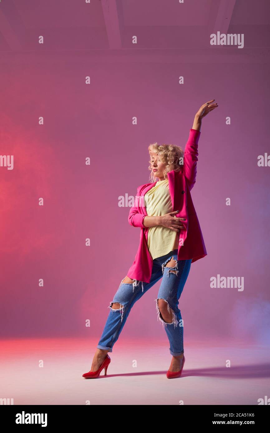modern dancer poses in front of the studio background, looking away ...