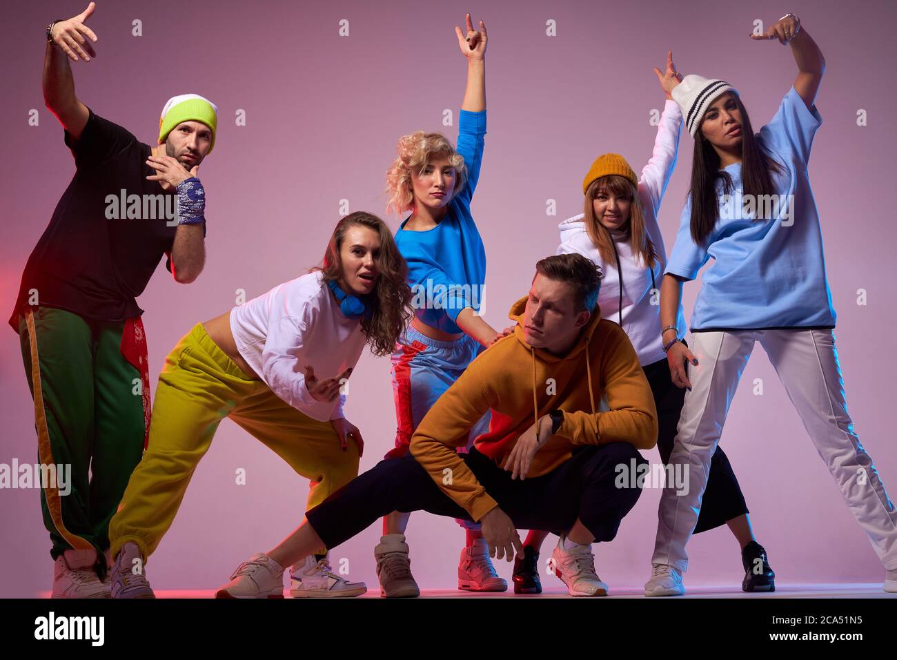 Professional male dancer sitting on squats in sportswear looking away ...