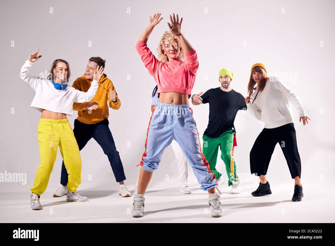 Joyful active group of friends dancing together on dance floor ...