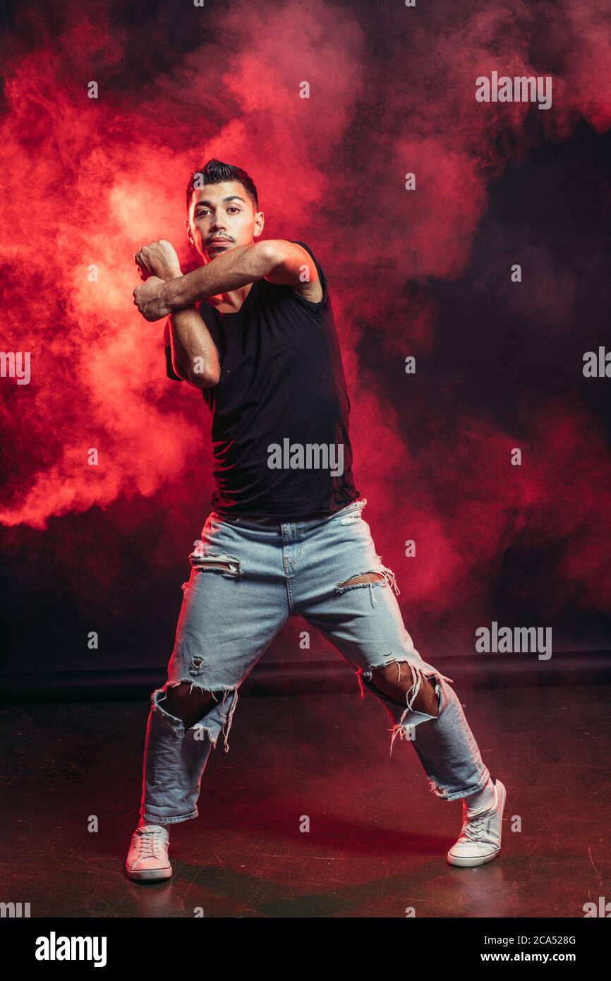 handsome man dancing isolated over smoky background, wearing casual ...