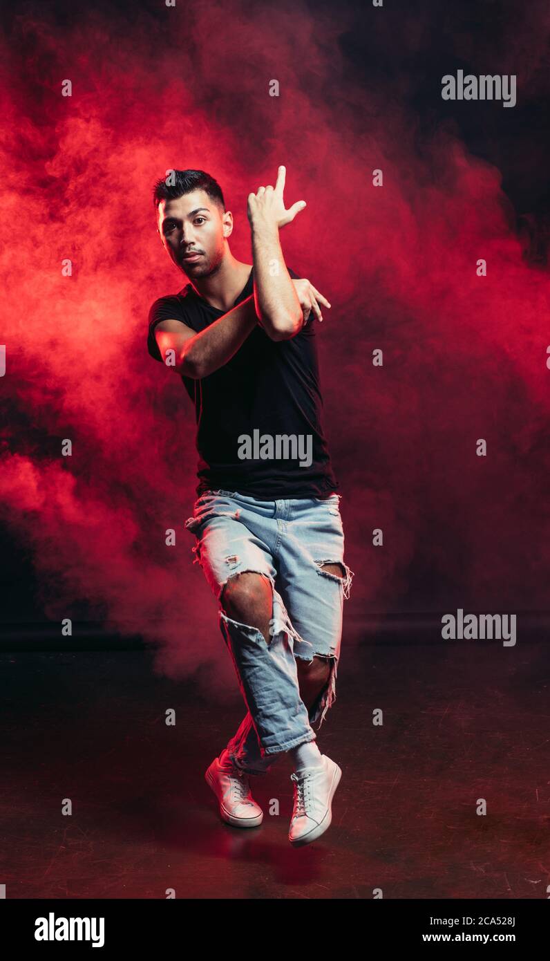 athletic male dancing street dance isolated over smoky background ...