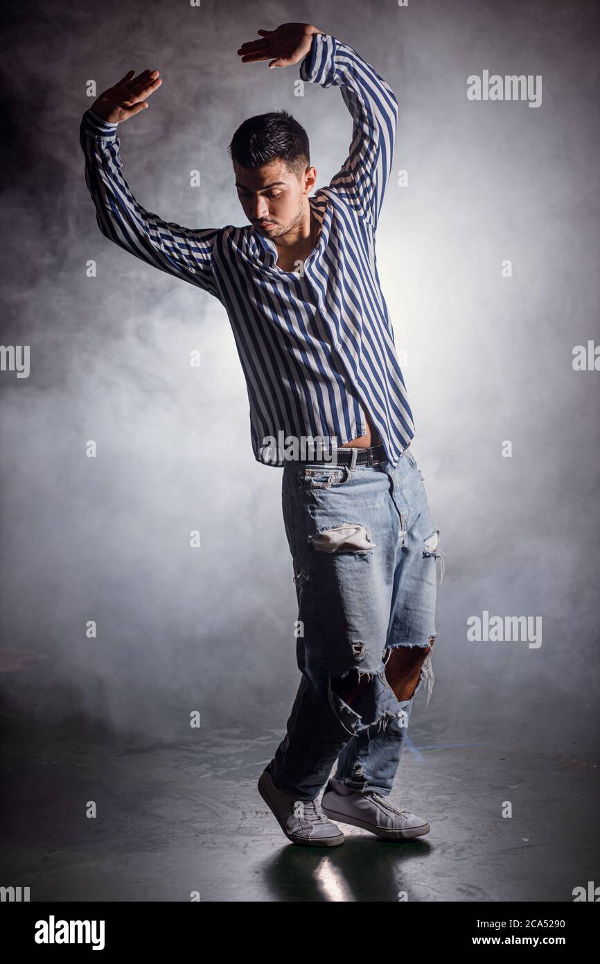 professional male dancer dancing isolated over smoky background, with ...