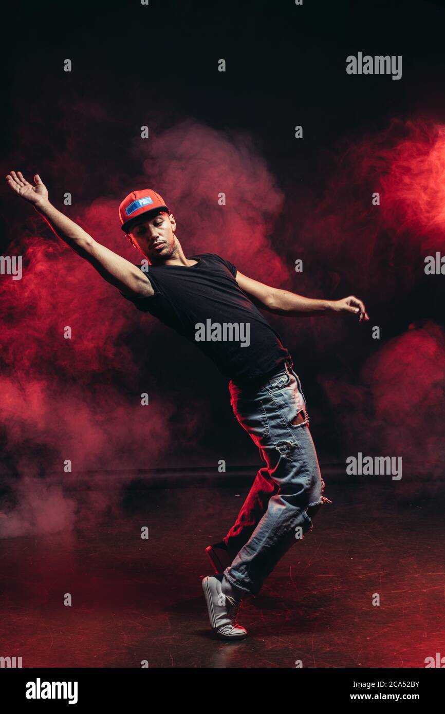 athletic male dancing street dance isolated over smoky background ...