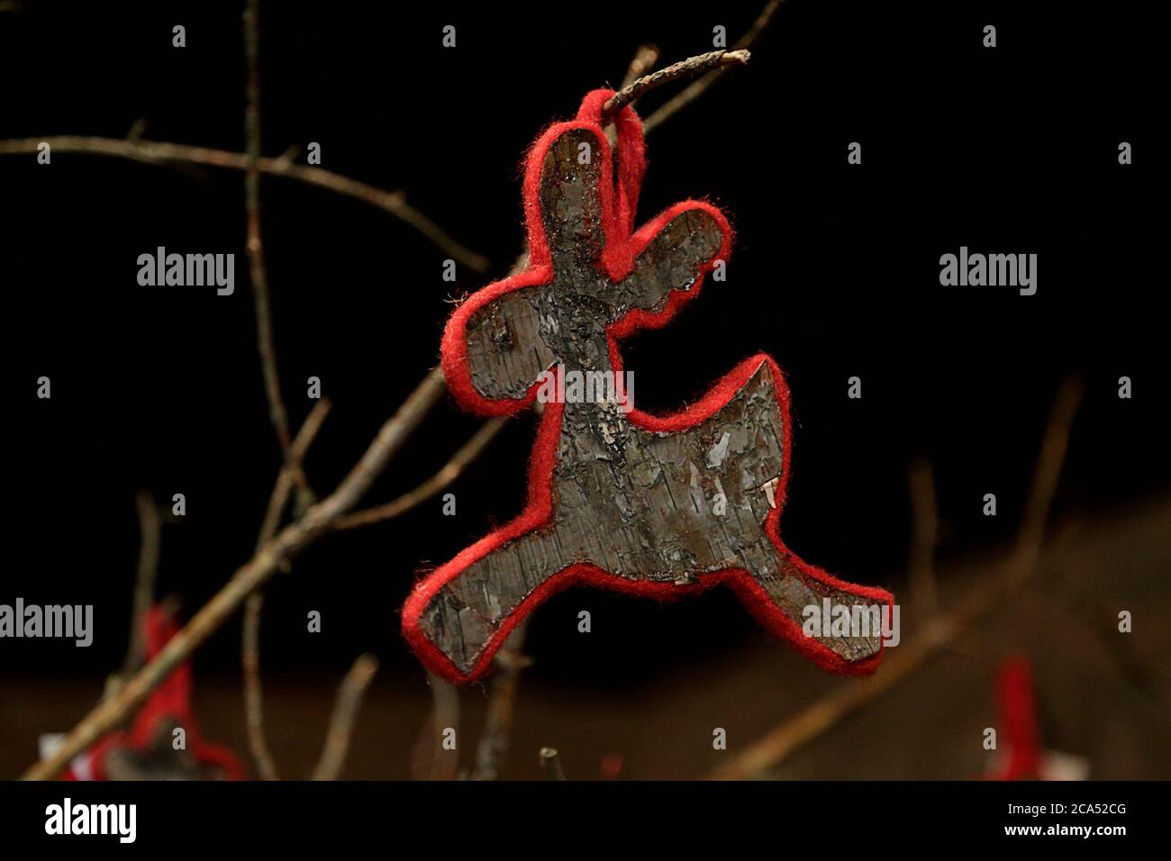 Wooden christmas ornament shaped as reindeer hanging on a dry tree ...