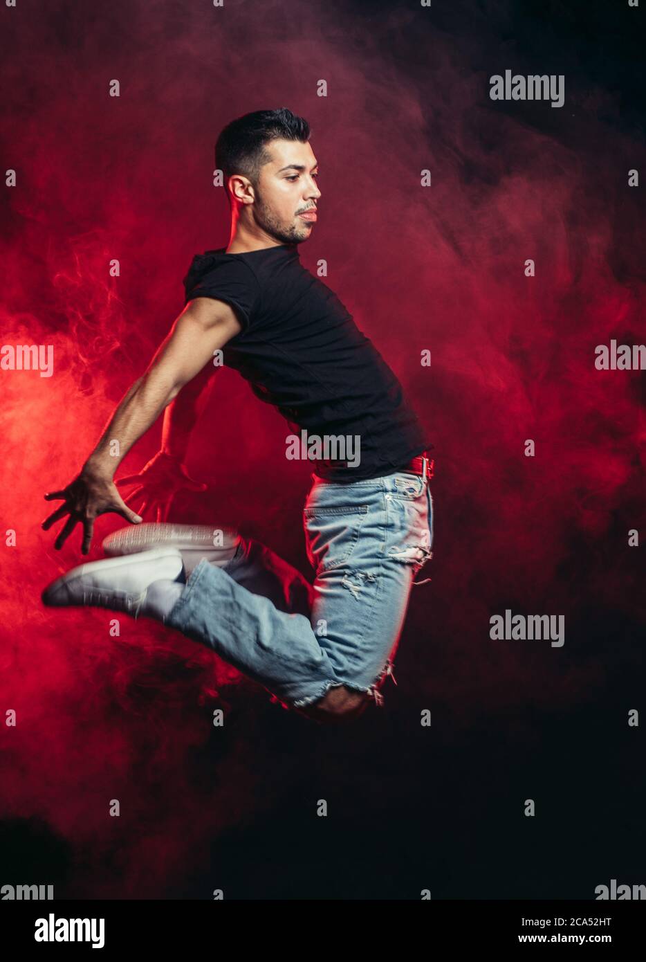 athletic male dancing street dance isolated over smoky background ...