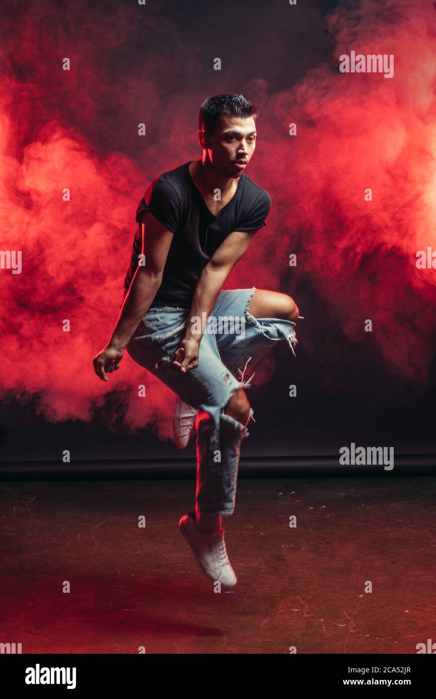 portrait of vigorous dancer male dancing street dance, jump in the air ...