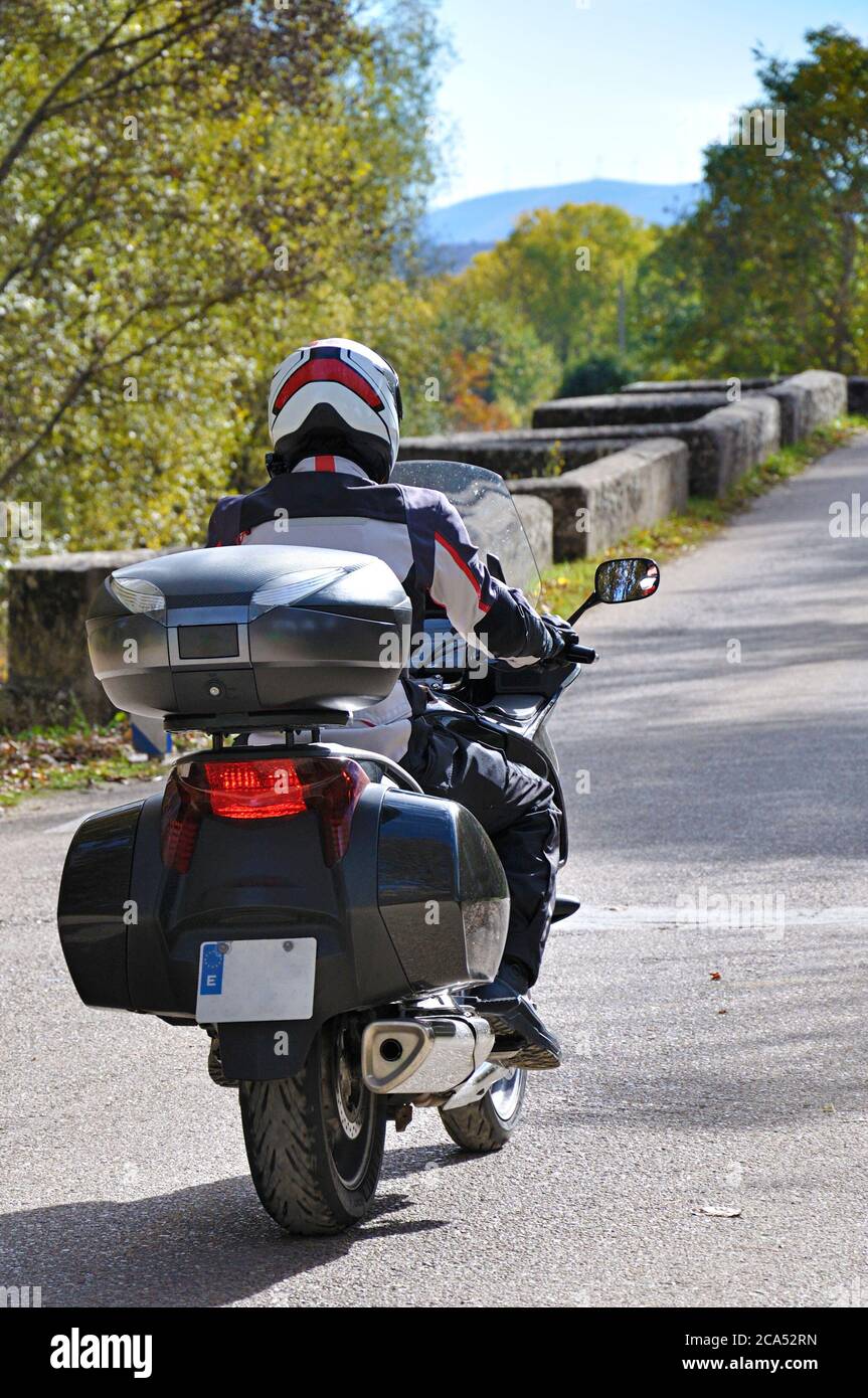 Rear view of a biker on a road Stock Photo - Alamy