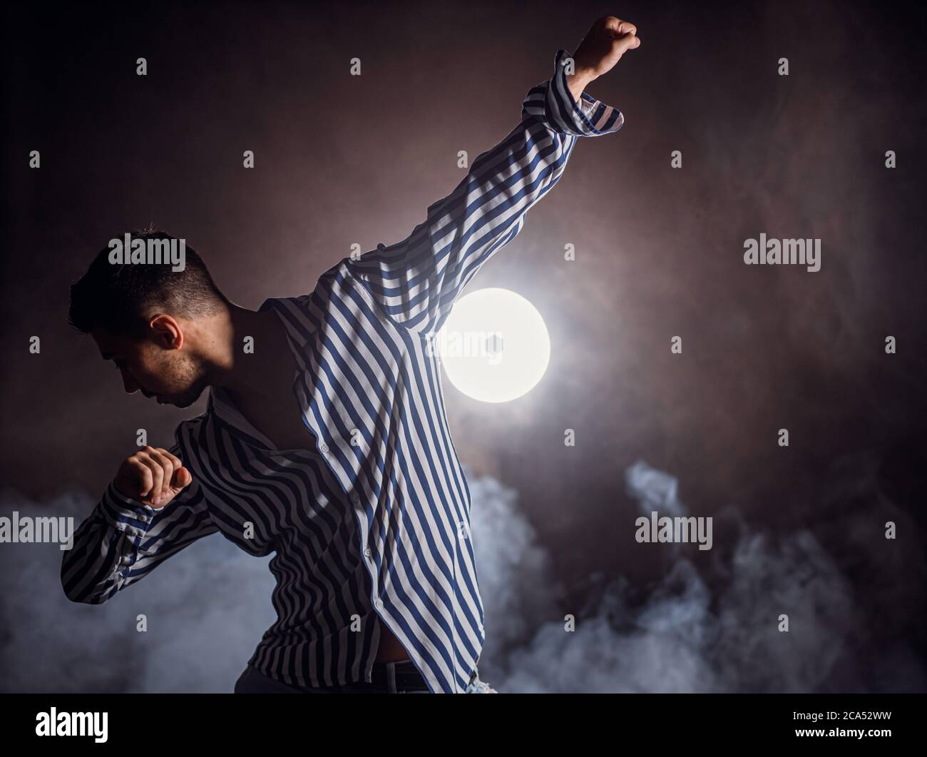 professional male dancer dancing isolated over smoky background, with ...