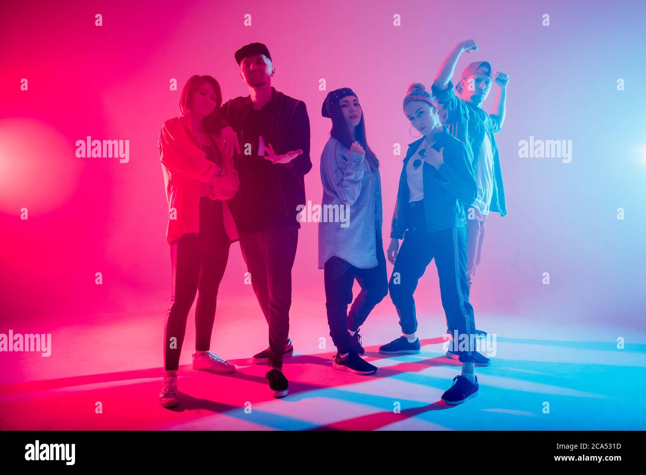 Group of male and female dancers in colorful neon light having fun ...