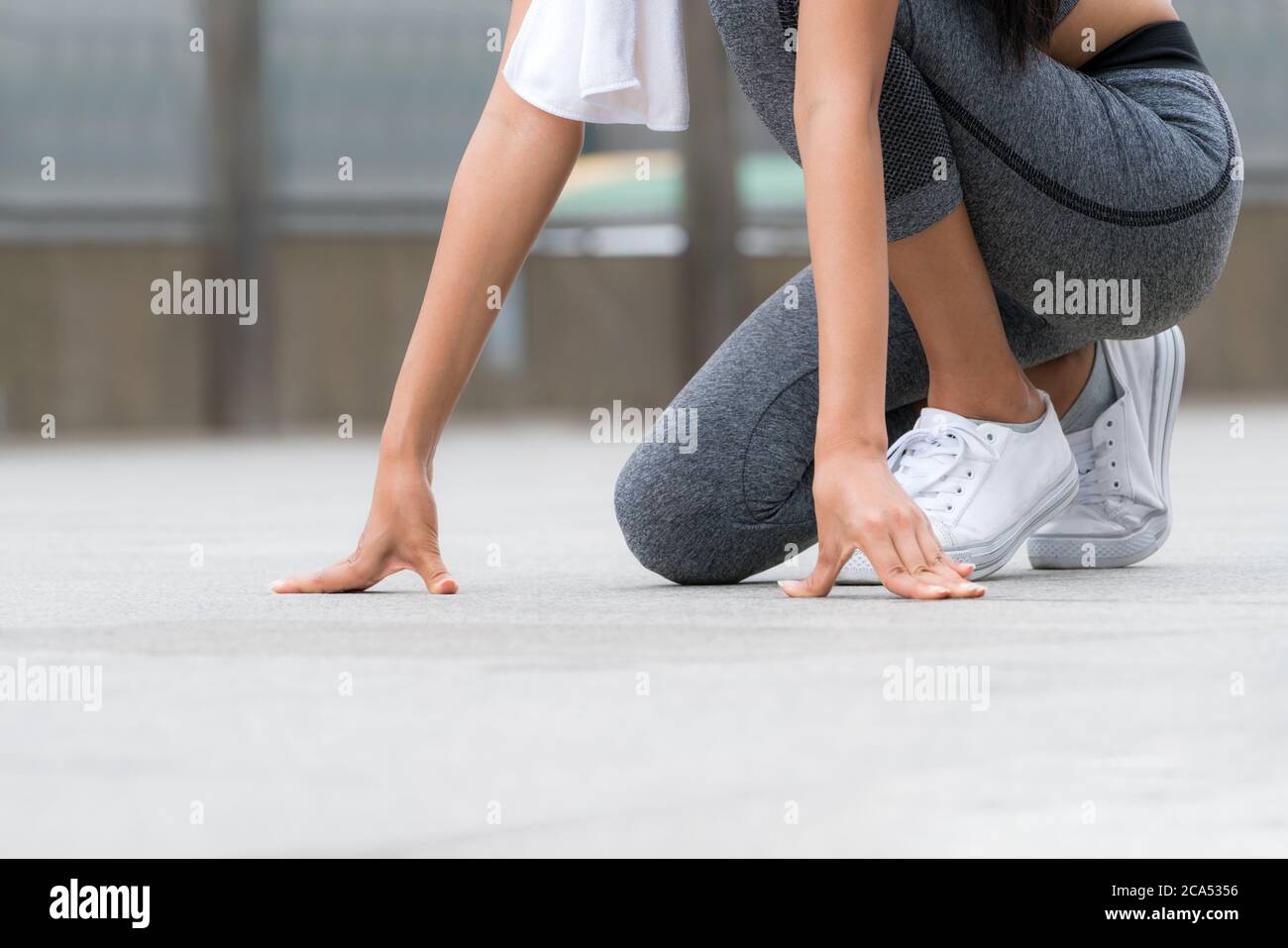 Woman runner in starting running position Stock Photo - Alamy