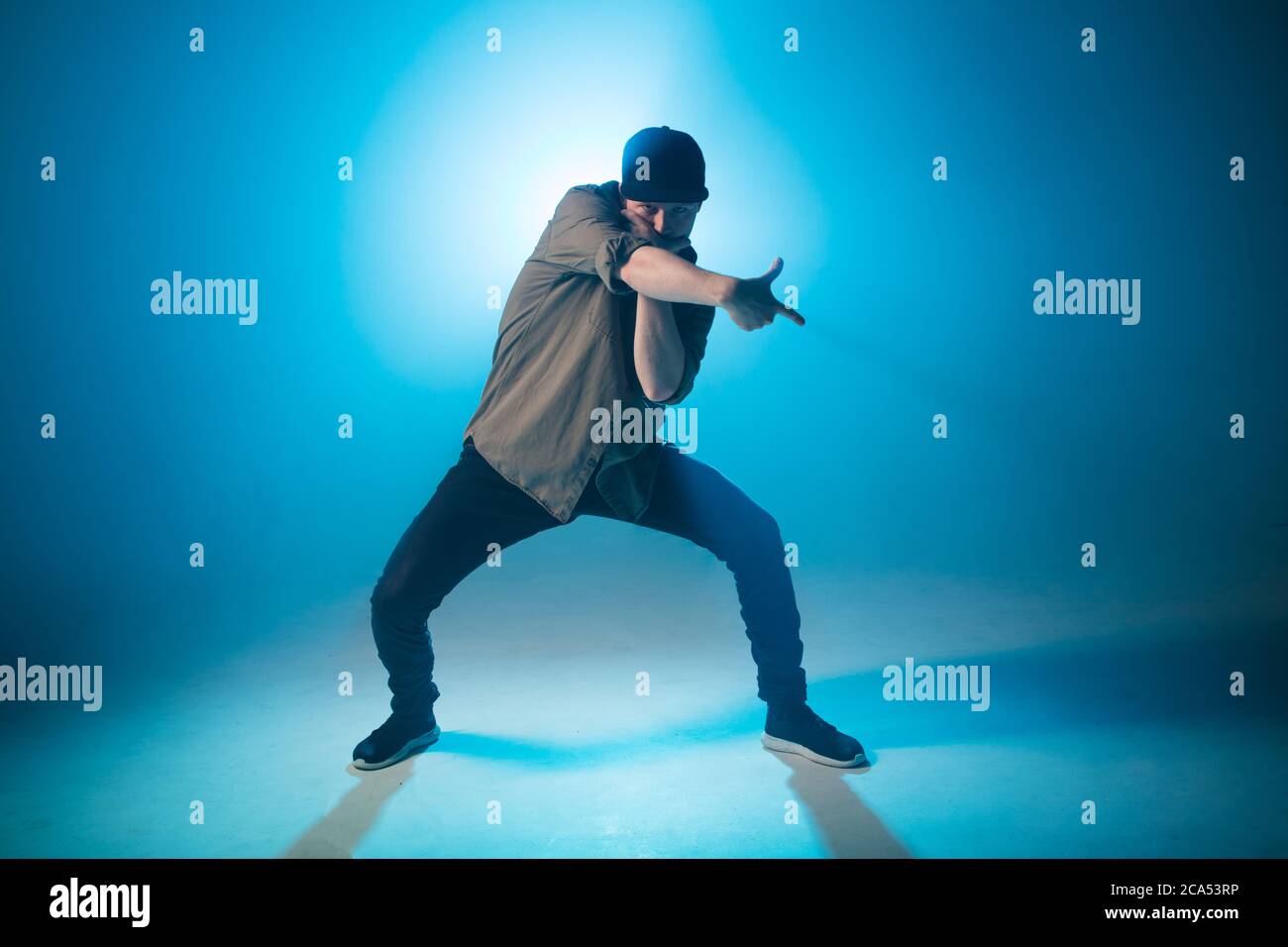 Stylish young man wearing trendy streetwear is dancing contemporary ...