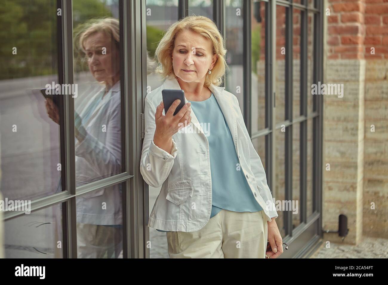 Elderly caucasian pretty business woman about 62 years old with mobile ...