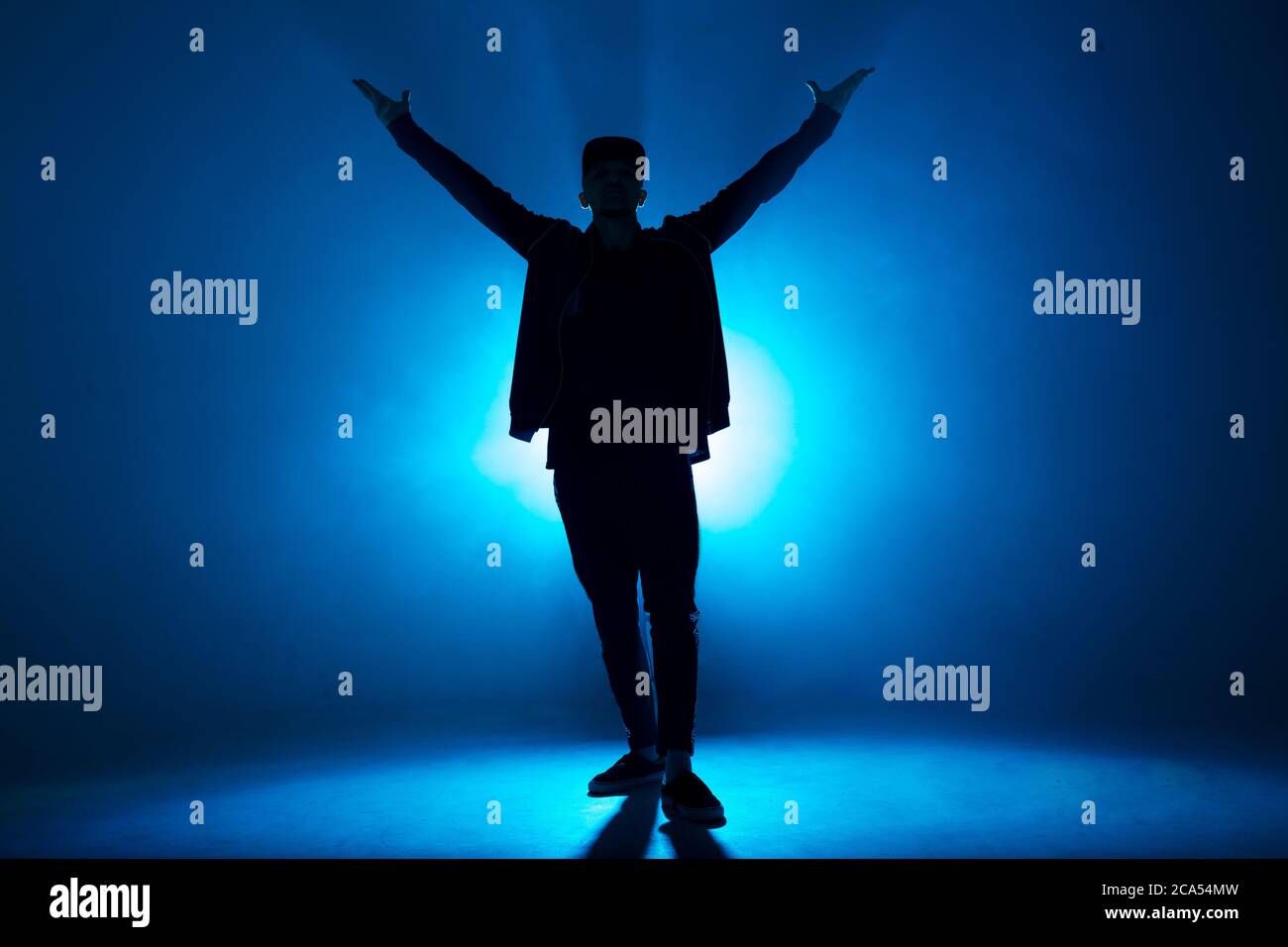 Full-size of silhouette of male break dancer performing on blue neon ...
