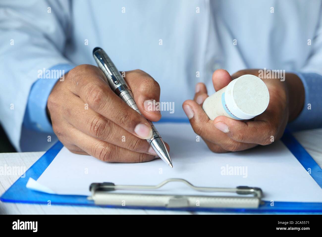doctor hand writing prescription on desk, close up Stock Photo - Alamy