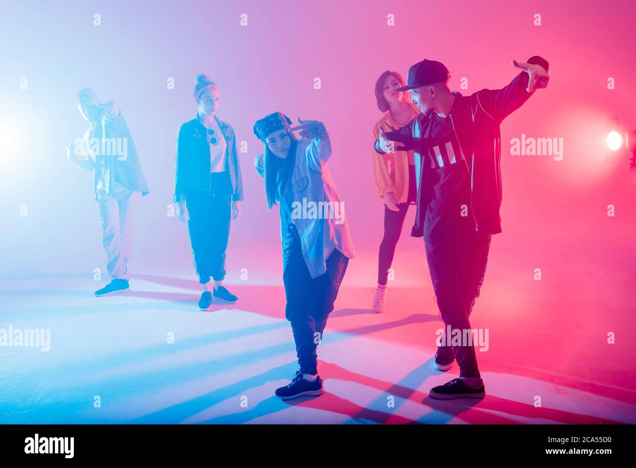 Group of male and female dancers in colorful neon light having fun ...