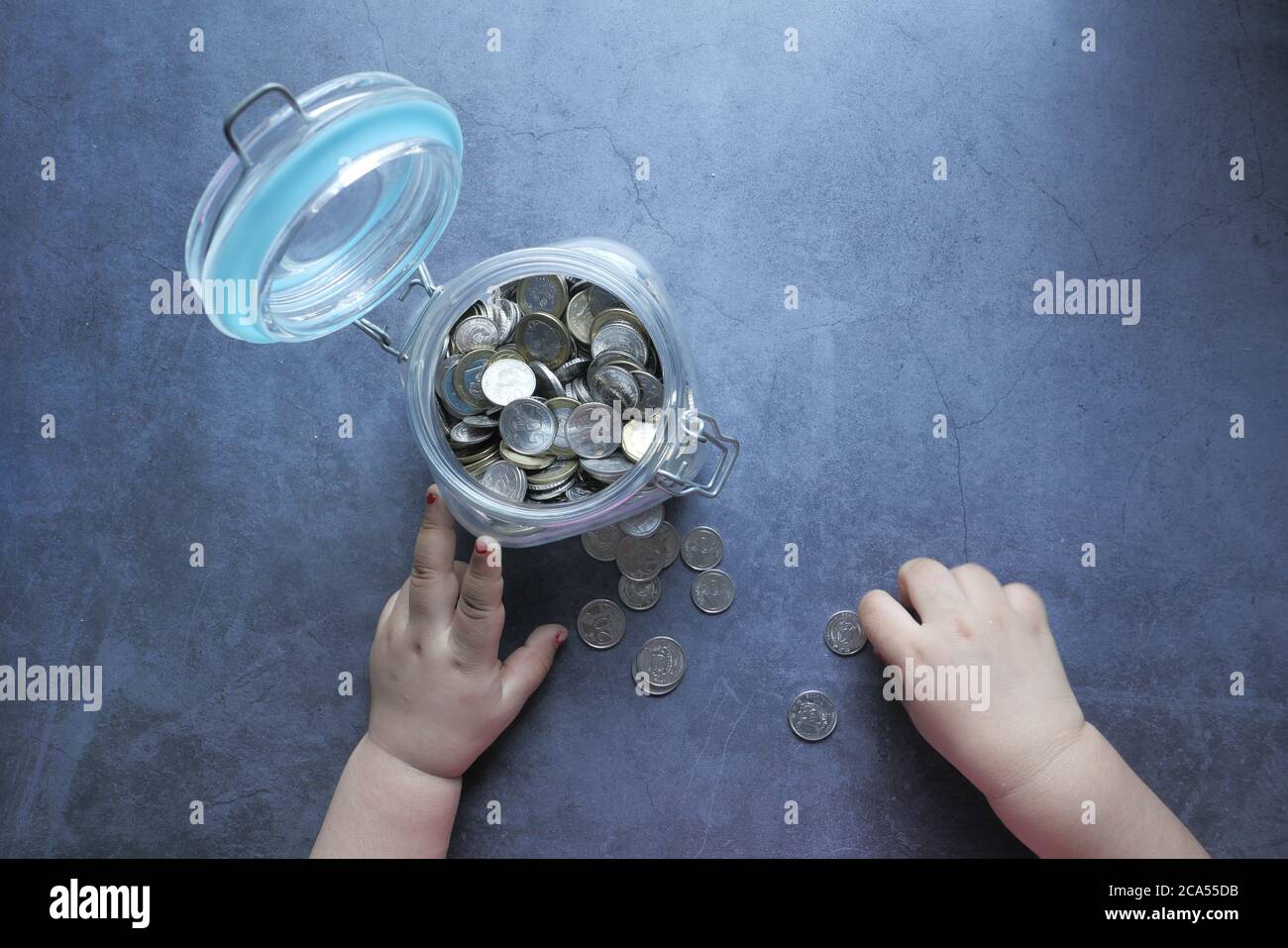 Top view of baby child saving coins in a jar Stock Photo - Alamy