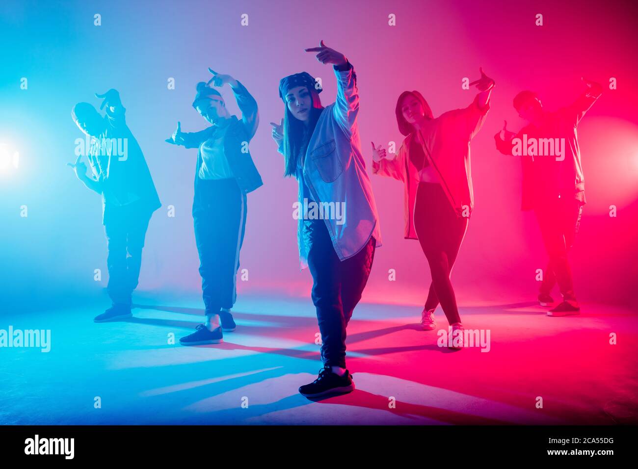 Group of diverse young hip-hop dancers in studio with special lighting ...