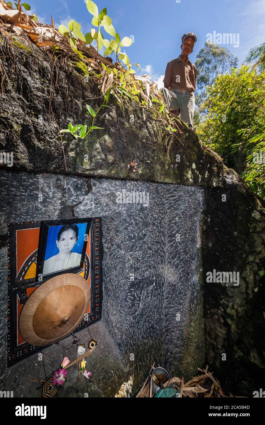 Indonesia, Sulawesi, Tana Toraja, Bori, man looking at a tomb dug in ...