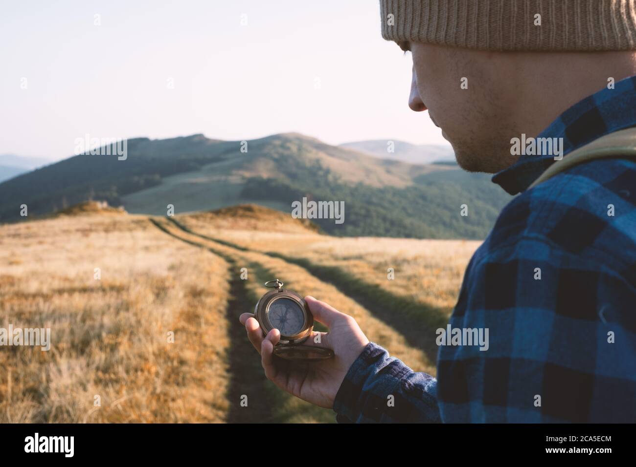 Man with old compass in hand on mountains road. Travel concept ...