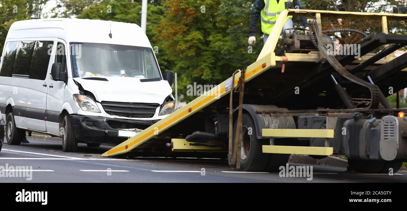 Wrecked minibus stands next to tow truck closeup Stock Photo - Alamy