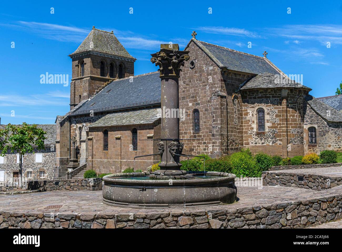 France, Cantal, fountain and church in the village of Trizac, regional ...